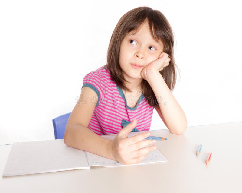 Child Writing Her Homwork at a Desk with a Blue Pencil Crayon Stock ...
