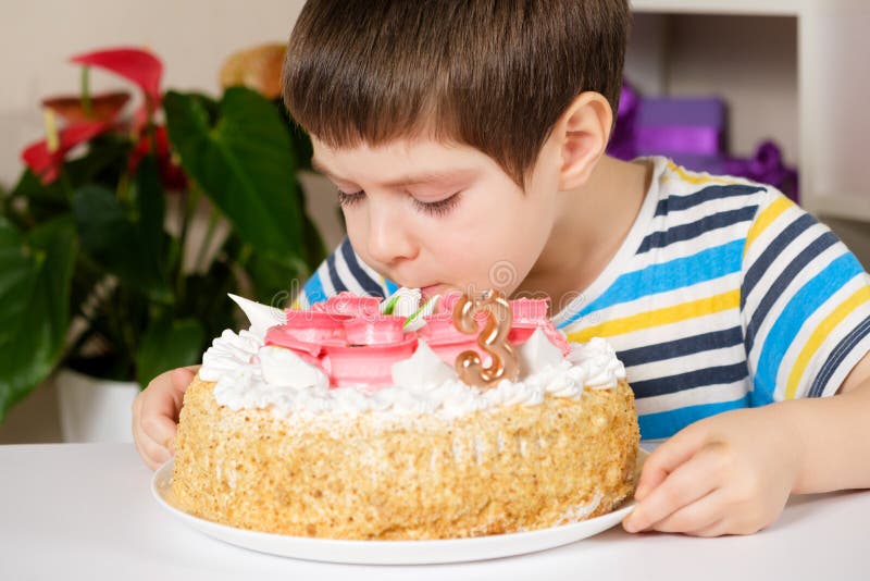 A Child of 3 Years Old Eats a Birthday Cake, Licks the Cream from the ...