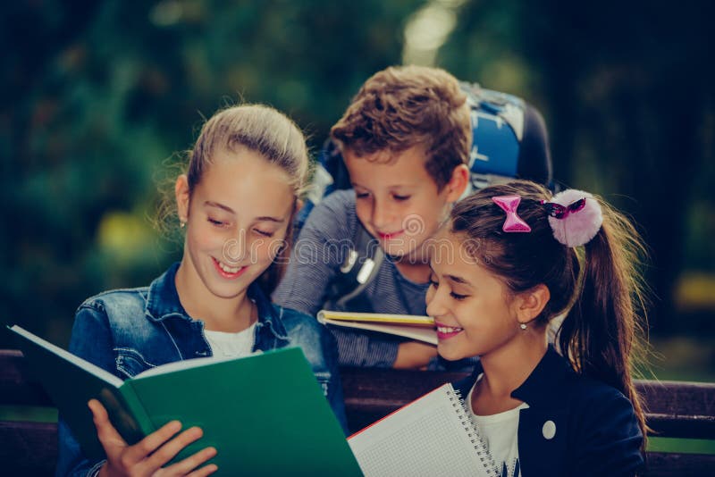 Children with Backpacks are Having Fun, Talking, Reading a Book Stock ...