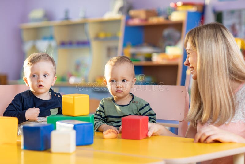 Children Building Blocks with a Teacher in the Nursery Stock Photo ...