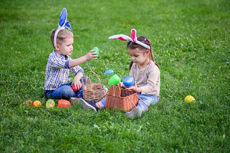 Children Collecting Easter Eggs Outdoors in Bunny Ears Stock Photo ...