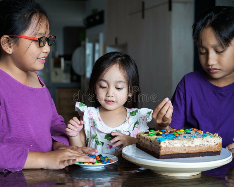 Children Decorating Their Birthday Cake with Chocolate and Sweets Stock ...
