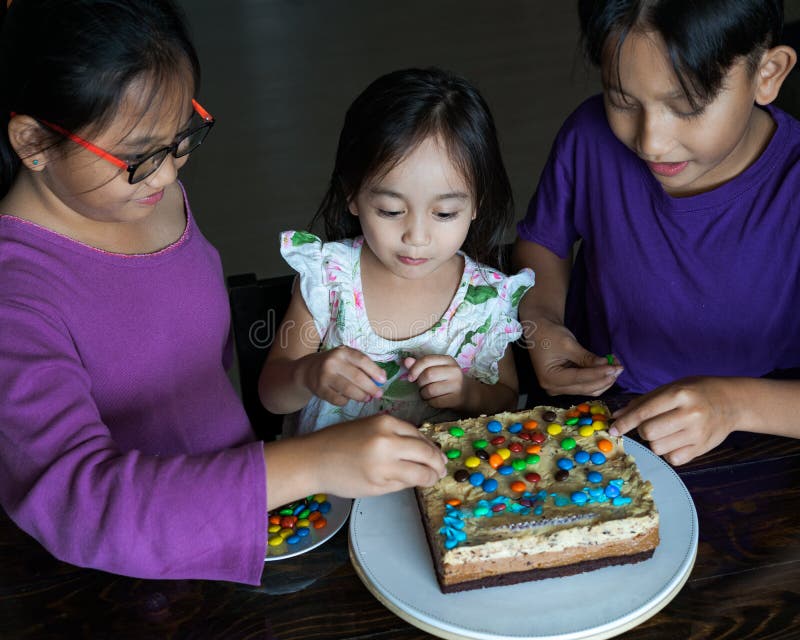Children Decorating Their Birthday Cake with Chocolate and Sweets Stock ...
