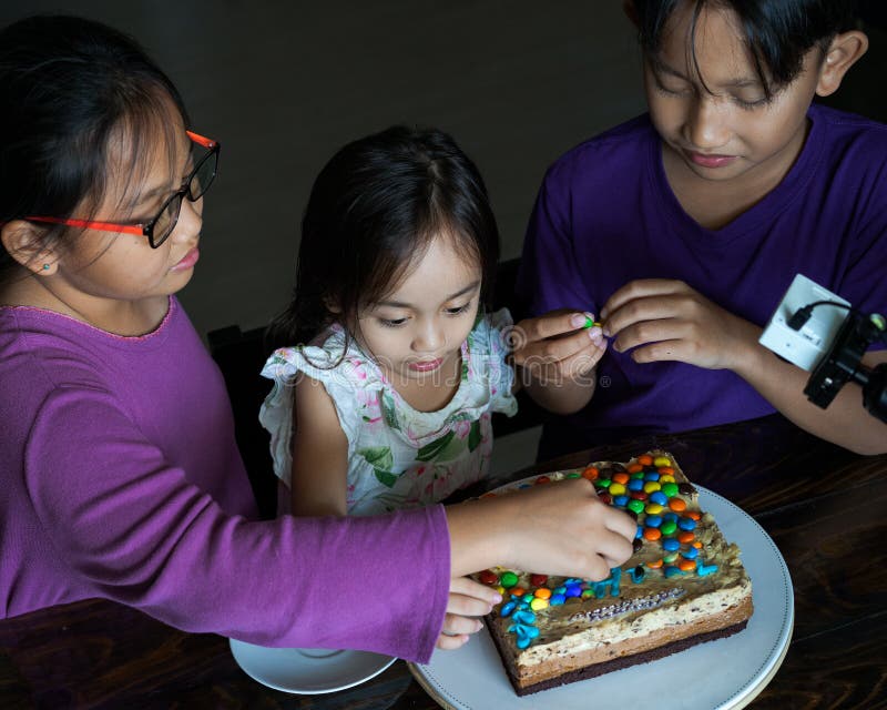 Children Decorating Their Birthday Cake with Chocolate and Sweets Stock ...