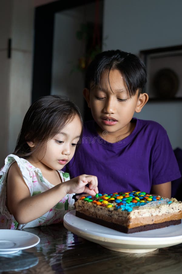 Children Decorating Their Birthday Cake with Chocolate and Sweets Stock ...