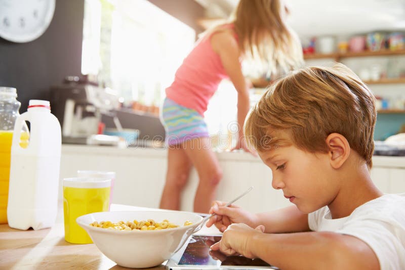 Children Eating Breakfast and Playing with Digital Tablet Stock Image ...