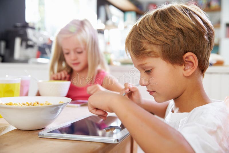 Children Eating Breakfast Whilst Using Digital Tablet Stock Image ...