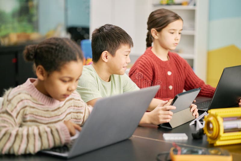 Children Engaging in Classroom with Digital Devices Stock Image - Image ...