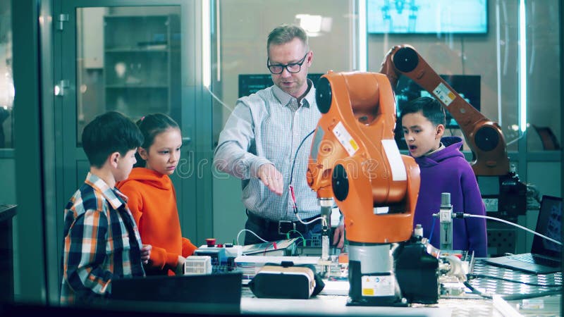 Children and an Engineer are Observing a Robotic Arm at School Lab ...