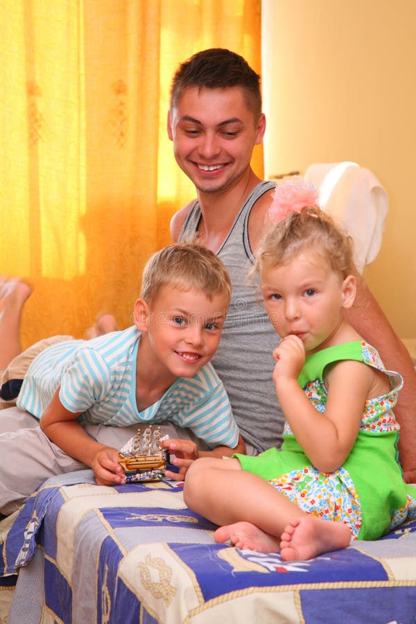 Children with Father Sitting on Bed in Room Stock Photo - Image of ...