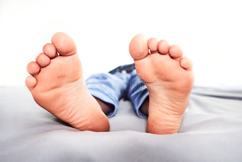Children feet lying on bed stock image. Image of foot - 199580757