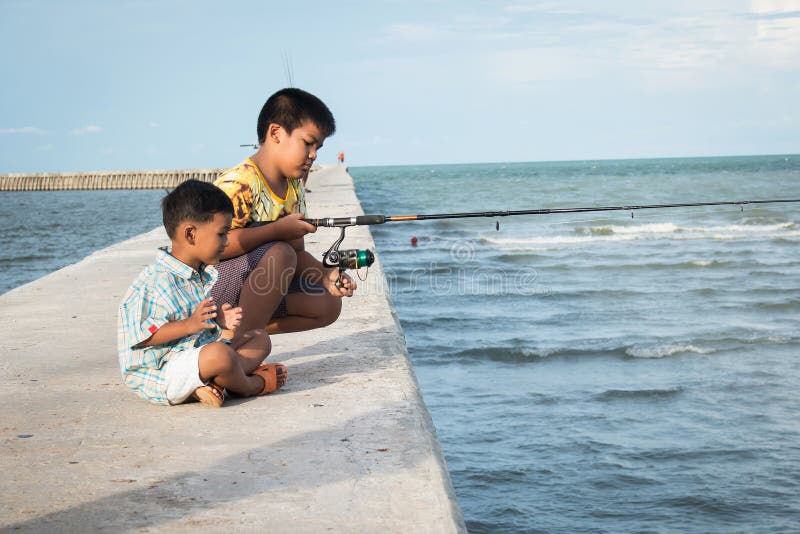Children fishing at sea stock image. Image of together - 76787943