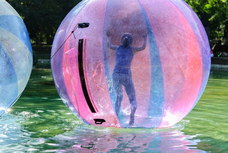 Children Have Fun Inside Plastic Balloons on the Water. Stock Photo ...