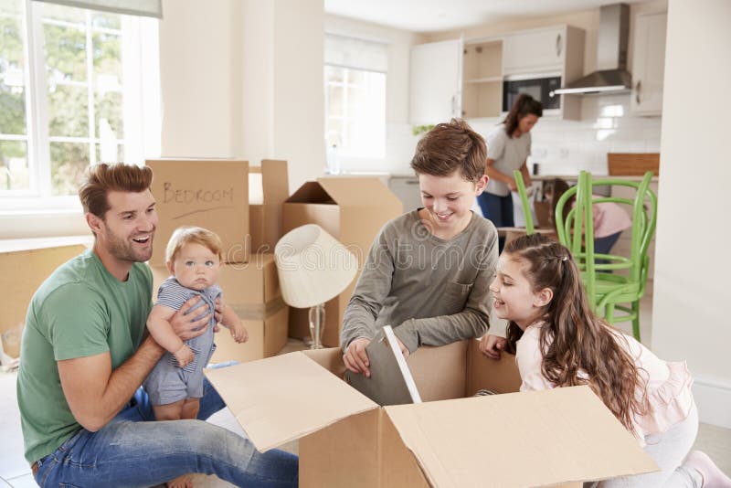 Children Helping Parents To Unpack on Moving in Day Stock Image - Image ...