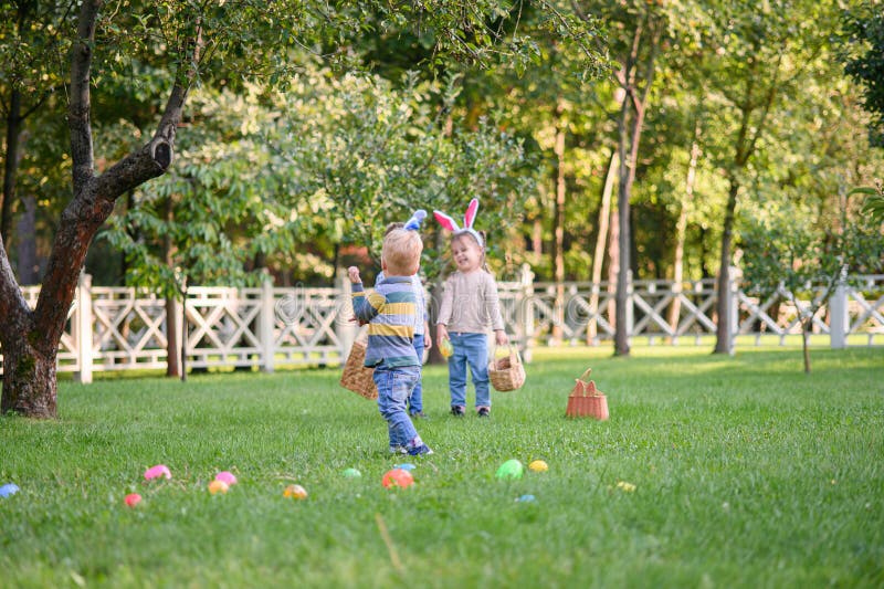 Children Hunting Easter Eggs in the Garden with Bunny Ears Stock Image ...