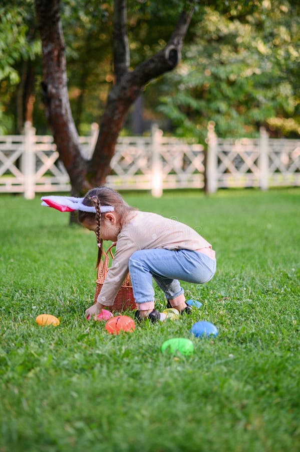 Children Hunting Easter Eggs in the Garden with Bunny Ears Stock Photo ...