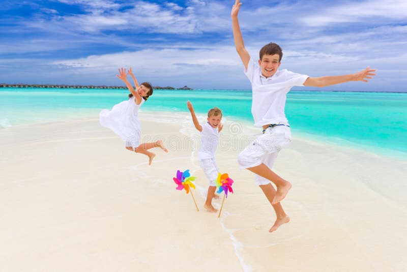 Kids jumping at the beach stock photo. Image of water - 2605082