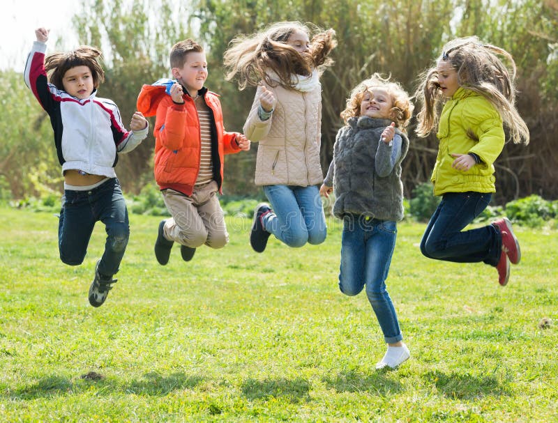 Children jumping outdoors stock photo. Image of caucasian - 77546676