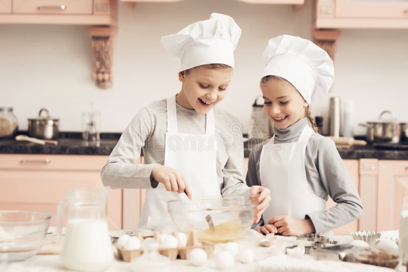 Children in Kitchen. Brother and Sister are Whisking Eggs with Fork ...