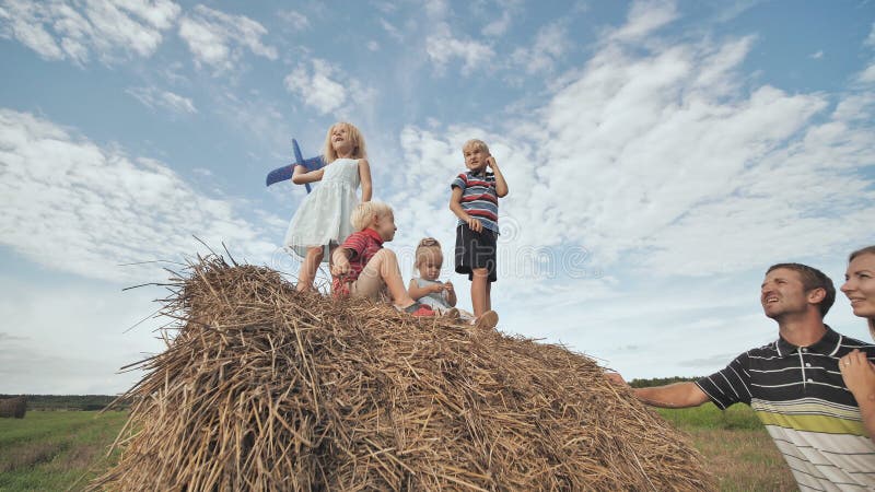 Children Launch Airplanes while Standing on a Stack of Straw in Front ...