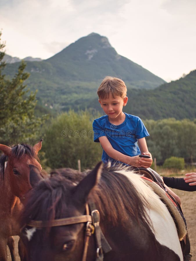 Children Learn To Ride Horses by the River until Sunset. Stock Photo ...