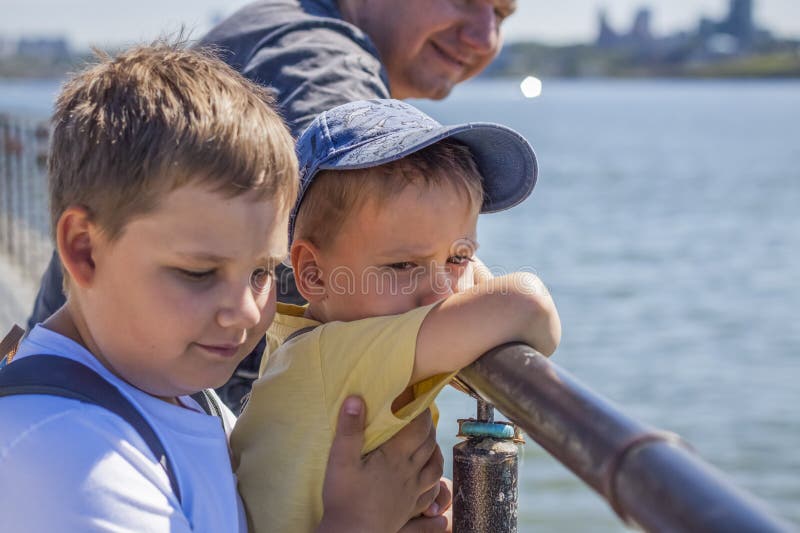 Children and a Man Stand and Look at the River Over the Railing of the ...