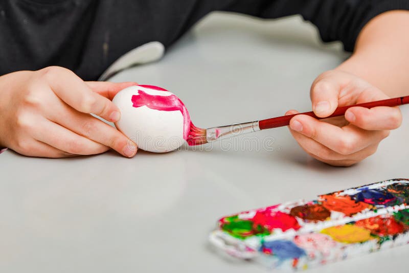 Children Paint Eggs for Easter, Paints Draw Patterns on a White Egg ...