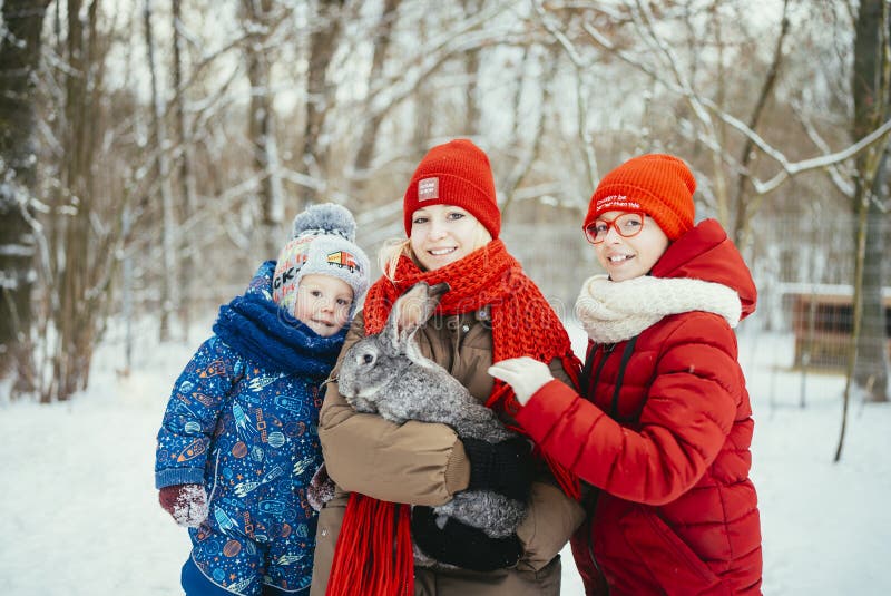 Children Petting a Rabbit and Laughing in Winter on a Cold Day Stock ...
