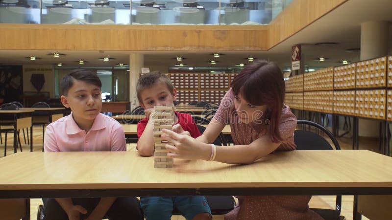 Two Children in the Library in Front of an Electronic Tablet while ...