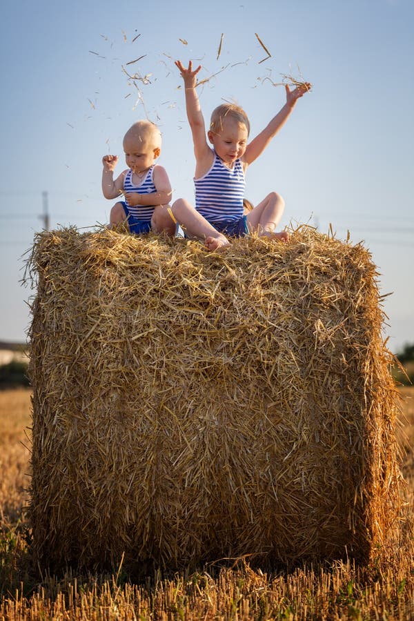 Children Play Sitting on a Haystack Stock Image - Image of play, hands ...