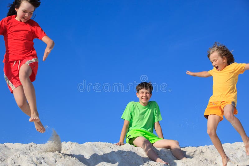 Kids jumping at the beach stock photo. Image of water - 2605082