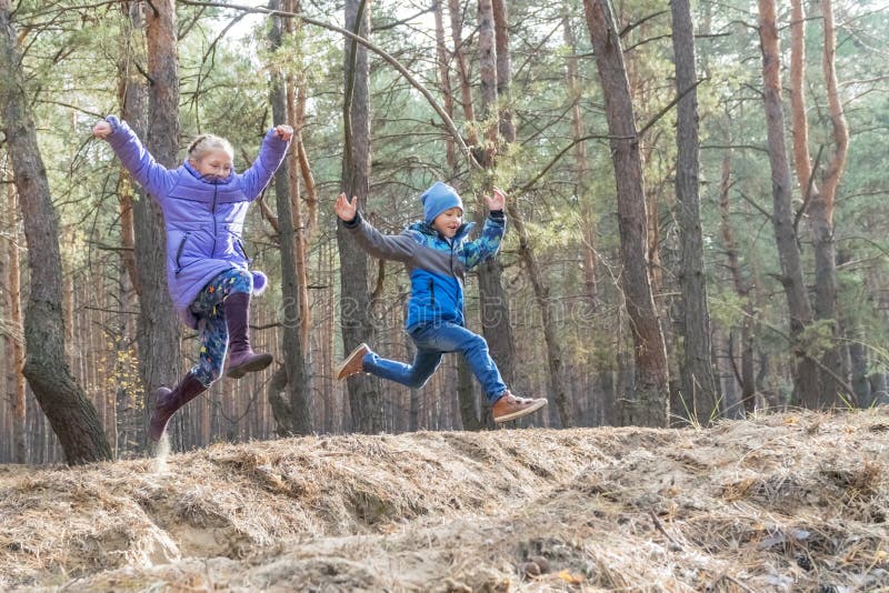 Children jump over the pit stock photo. Image of game - 131789478