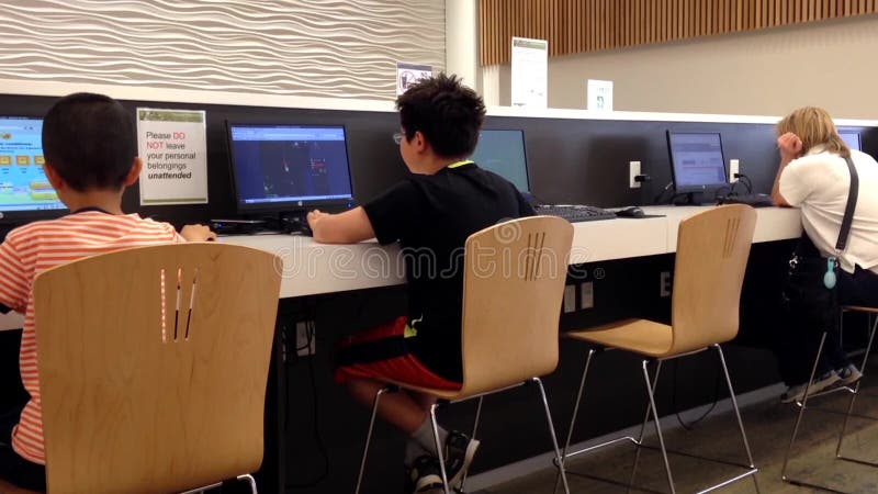 Two Children in the Library in Front of an Electronic Tablet while ...