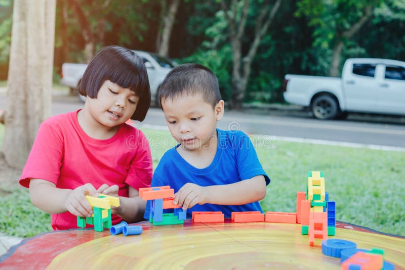 Children Playing with Plastic Bricks on a Marble Table Educational Toys ...
