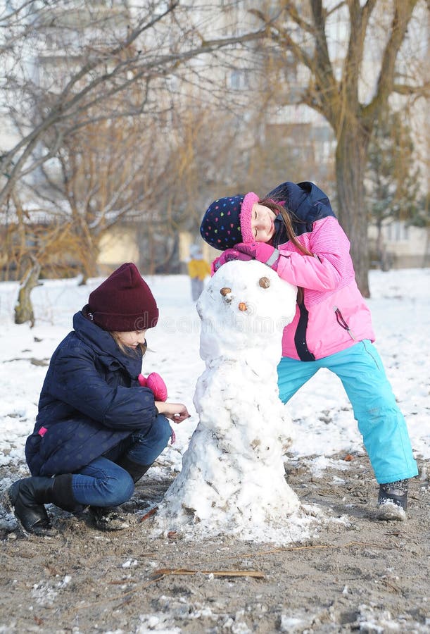 Children Playing with a Snowman Outdoors Stock Photo - Image of child ...