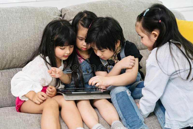 Children Playing on Tablet. Group of Kids Playing with Laptop Together ...