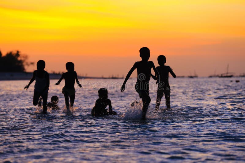 Children Playing in Water at Sunset Editorial Stock Photo - Image of ...