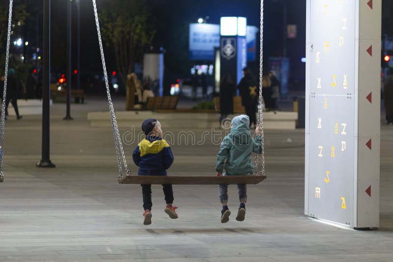 Children Ride on a Swing on the Street at Night Editorial Photography ...