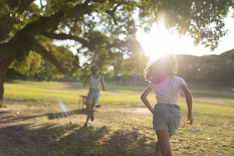 Children Running Joyfully in Sunlit Park Stock Image - Image of ...