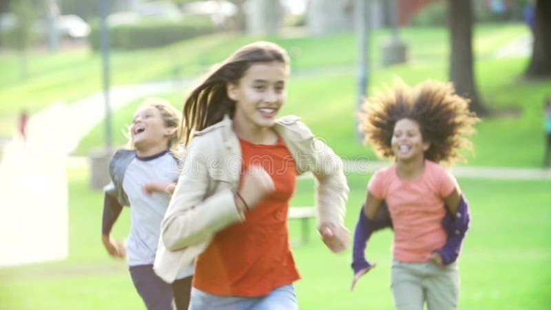 Young Girls Using Digital Tablets and Mobile Phones in Park Stock ...