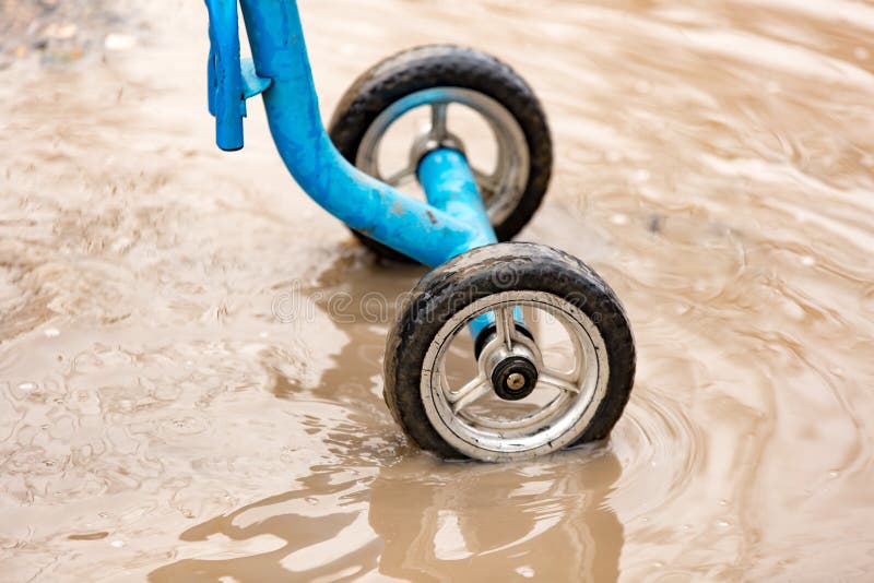 Children`s Bicycle Wheels in a Puddle on the Road Stock Image - Image ...