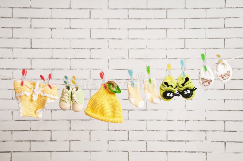 Children`s Clothes Hanging on a Rope Against a White Brick Wall. Stock ...