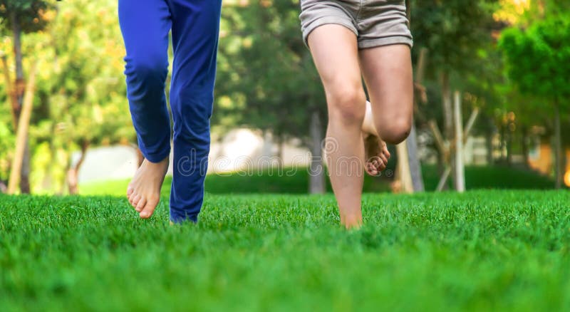Children& X27;s Feet Go on the Grass. Selective Focus Stock Photo ...