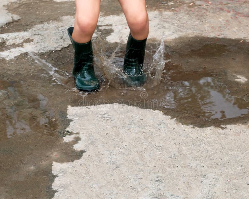 Children`s Feet in Jumping Over a Puddle in the Rain Stock Photo ...