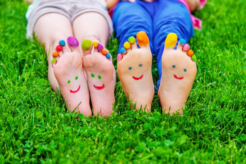 Children& X27;s Feet with a Pattern of Paints Smile on the Green Grass ...