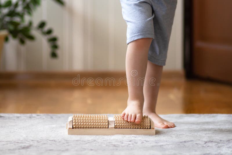 Children& X27;s Feet on a Wooden Roller Massager, Front View, Middle ...