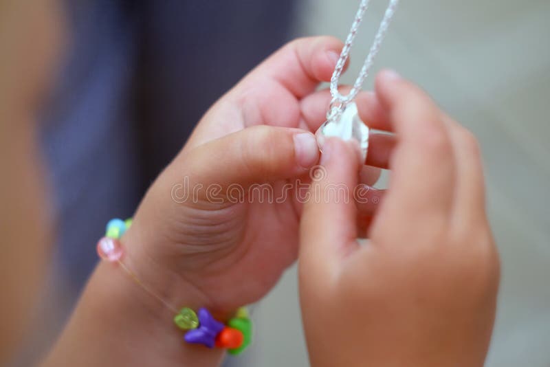 Children& X27;s Hands Holding a Beautiful Chain with a Pendant so Close ...