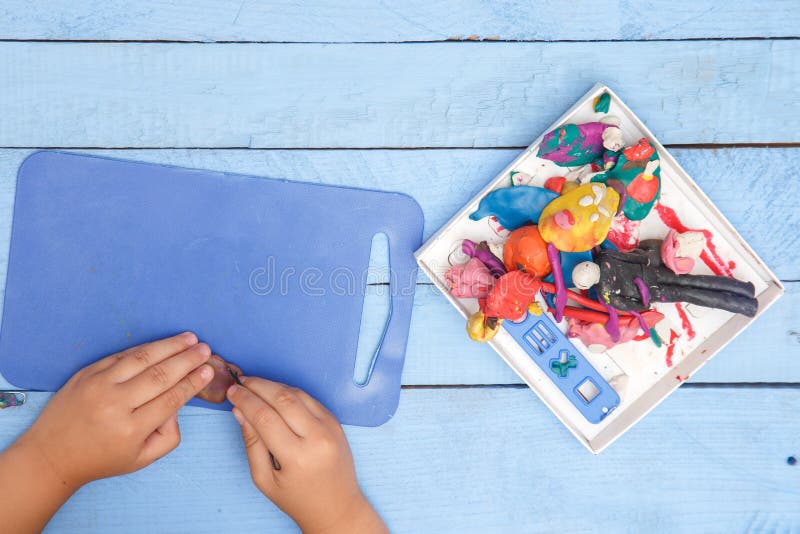 Children`s Hands Sculpt Figures of Clay on a Blue Table. the View from ...
