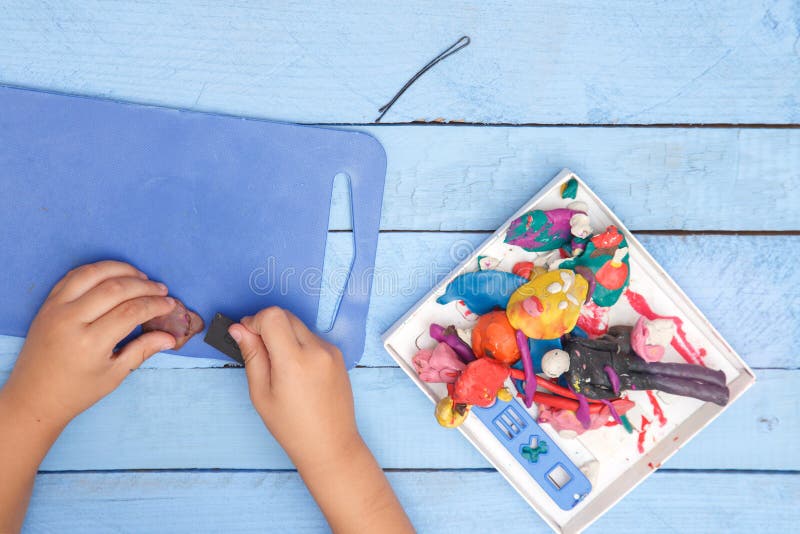 Children`s Hands Sculpt Figures of Clay on a Blue Table. the View from ...