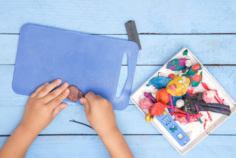 Children`s Hands Sculpt Figures of Clay on a Blue Table. the View from ...